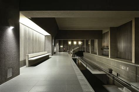 A Brutalist Train Station Featuring Vast Concrete Walls Harsh Artificial Lighting And A Long