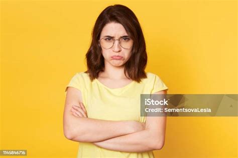 불쾌 한 얼굴 표정으로 감정 여자의 초상화를 닫습니다 부정적인 감정을가지고 여성은 노란색 배경 위에 고립 실망 느낌 남편에서 나쁜 소식을 받습니다 감정 개념 T 셔츠에 대한