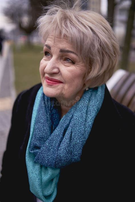 Portrait Of A Stylish Old Woman In A Black Coat With Green Accessories
