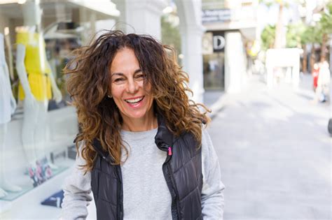 아름다운 스포티 한 여자 와 곱슬 머리 미소 쾌활한 산책 에 거리 에 The Town 곱슬 머리에 대한 스톡 사진 및 기타 이미지 곱슬 머리 거리 건강한 생활방식