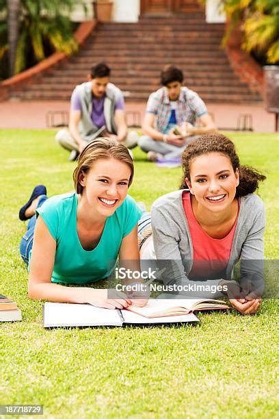Dua Gadis Perguruan Tinggi Dengan Buku Belajar Di Rumput Di Kampus Foto