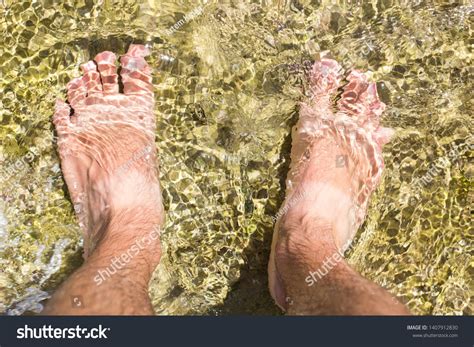 Bare Male Feet In Shallow Water On A Beach Summer Vacation Background