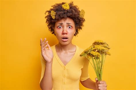 꽃가루 알레르기를 앓고 있는 여성은 충격을 받은 것처럼 보입니다 야생화에 알레르기 반응이 있습니다 눈이 가렵고 붉어지며