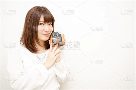 年轻女子拿着照相机，微笑着