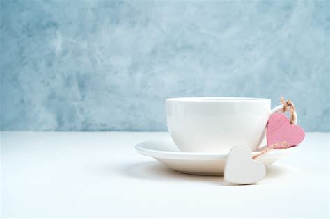 파란색과 흰색 배경에 커피 컵의 손잡이에 두 개의 하트가 묶여 있습니다 갈색에 대한 스톡 사진 및 기타 이미지 갈색 공휴일