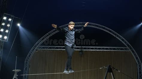 A Tightrope Walker Or Balancer Performs Tricks On A Tightrope In A