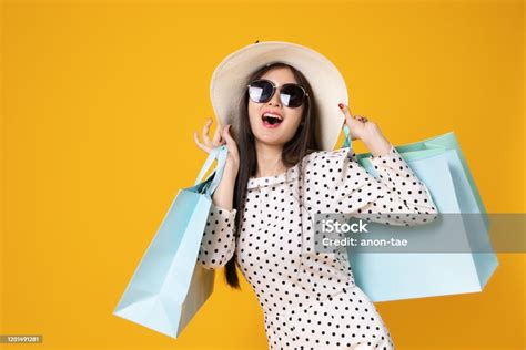 아시아 여자에 여름 캐주얼 옷입니다 그녀는 미소와 행복한 쇼핑 백 그녀는 노란색 배경에 사랑스러운 매력적인 빛 여름 서프라이즈