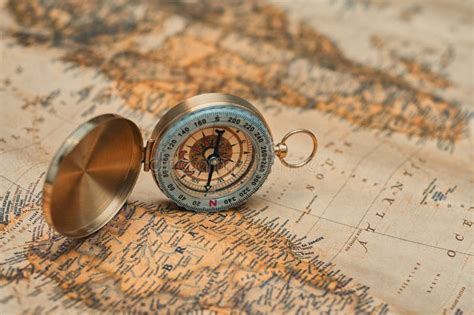 Antique Brass Compass Resting On A World Map Symbolizing Travel And