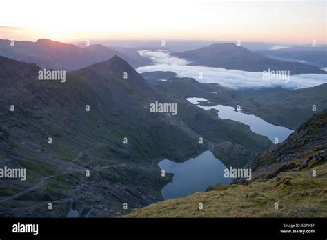 Sunrise At The Top Of Mt Snowdon In Wales With Lake And Clouds Below