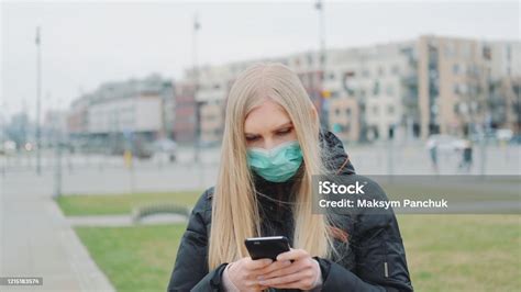 거리에서 코로나바이러스 질병에 대한 획기적인 뉴스를 읽는 의료 용 마스크를 착용한 여성 Covid 19에 대한 스톡 사진 및