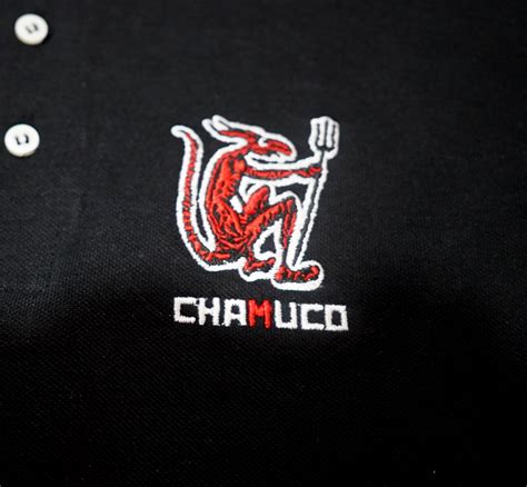 Playera De Manga Corta Con Botones Color Negro Logo Chamuco” El