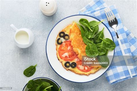 토마토 블랙 올리브 코티지 치즈 회색 콘크리트 배경의 흰색 접시에 녹색 시금치 허브를 곁들인 오믈렛 맛있는 아침 식사 건강한