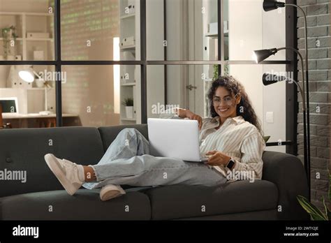 Female African American Programmer Working With Laptop On Sofa In