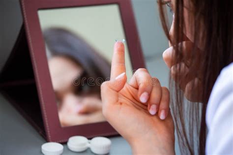 Young Woman Putting Contact Lens In Her Right Eye Close Up Stock Image