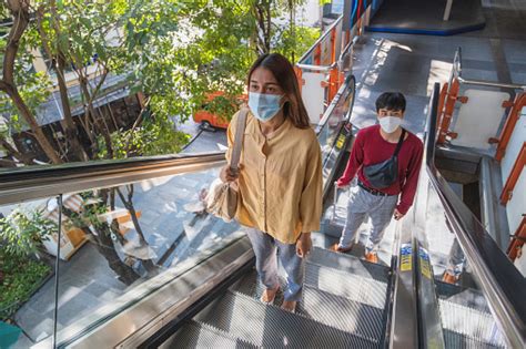 출근하는 동안 Mrt 지하 열차의 에스컬레이터에 보호 얼굴 마스크를 착용한 아시아 사업가 동료 20 29세에 대한 스톡 사진 및