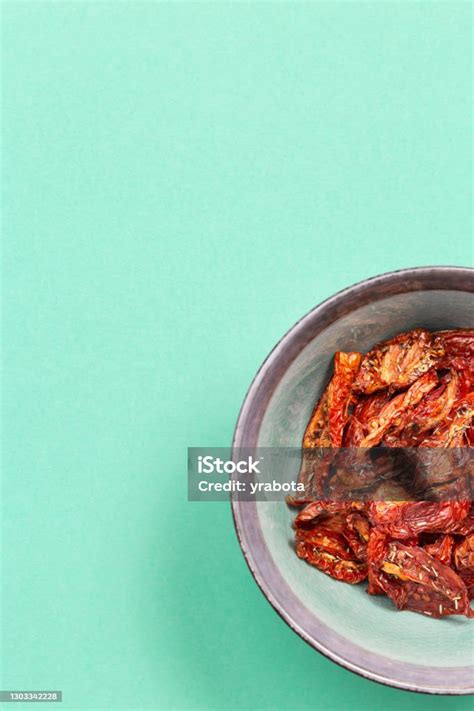 붉은 태양은 종이 배경에 세라믹 접시에 토마토를 건조 맛있는 작은 슬라이스 토마토 향신료와 올리브 오일 감자 칩에 대한 스톡
