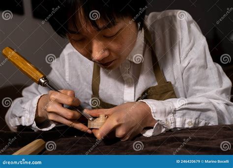 Young Chinese Female Violin Maker Working With Gouge To Making A New