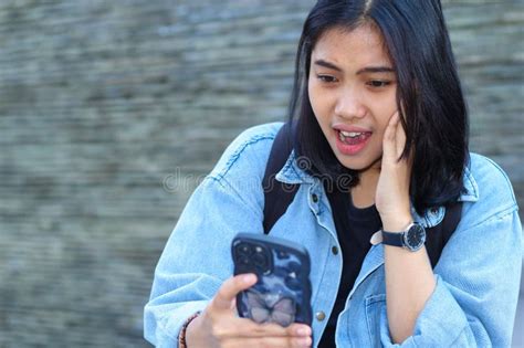 Shocked Asian Young Woman Traveler Smiling While Using Mobile