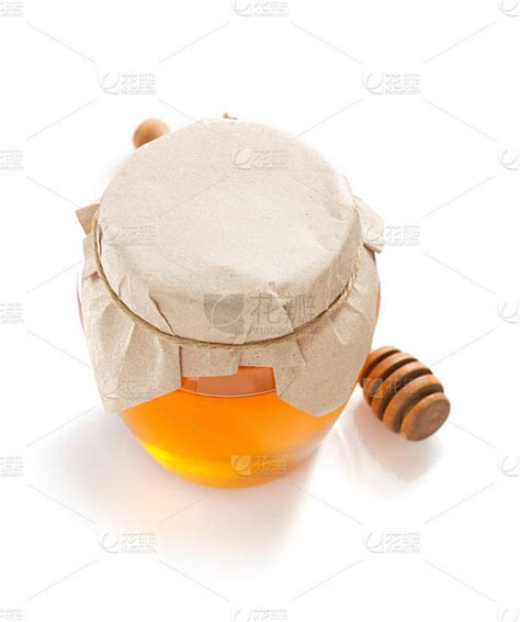 白色背景下装满蜂蜜的玻璃罐