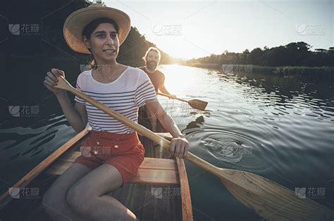 情侣们在夏日日落的湖面上划船