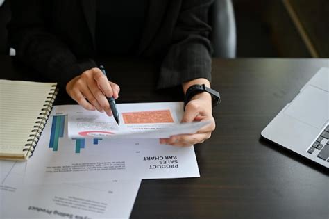 Uma gerente do sexo feminino está analisando os relatórios de marketing para a nova campanha