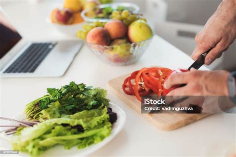 닫습니다 젊은이 운동 야채 맛 있는 샐러드를 준비합니다 그는 야채를 잘라냅니다 가구에 대한 스톡 사진 및 기타 이미지 가구