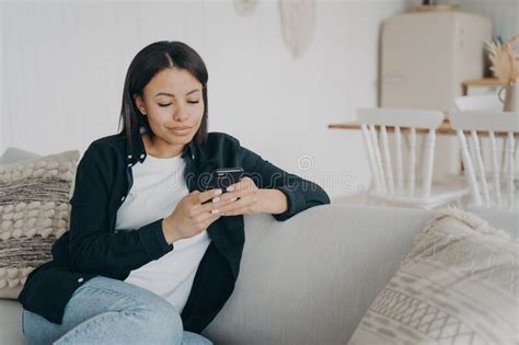 Female Uses Mobile Apps Holding Smartphone Chatting In Social Networks Shopping Online At Home