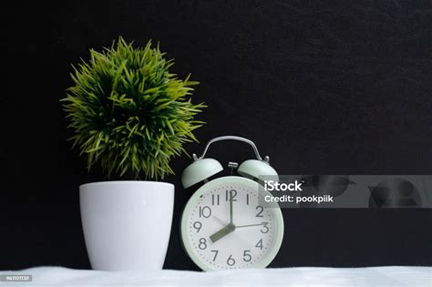 빈티지 알람 시계와 침실에서 집에서 침대에 흰색 꽃병에 작은 장식 나무 일어나 거 나 침대 시간 개념 0명에 대한 스톡 사진 및