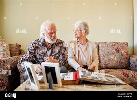 Senior European Couple Of Pensioners Sitting In Cozy Living Room
