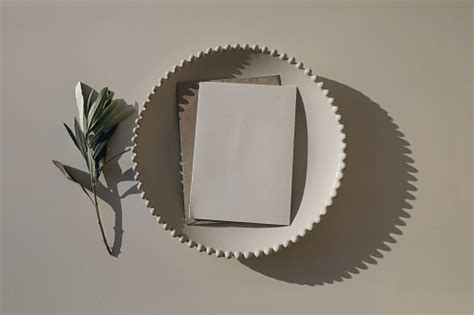 여름 결혼식 문구 모형 장면 빈 인사말 카드 초대장 흰색 세라믹 접시에 봉투 템플릿 베이지 색 테이블 배경에 올리브 나무 가지 지중해 평면 누워 평면도 0명에 대한 스톡