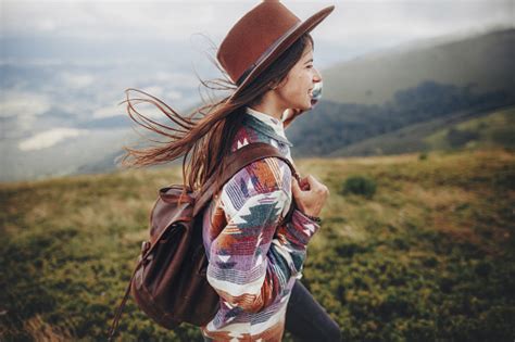 산에서 걷는 배낭 모자에 세련 된 여행자 소녀 소식통 여자 산 꼭대기 탐험입니다 텍스트를 위한 공간입니다 방 랑 벽과 여행