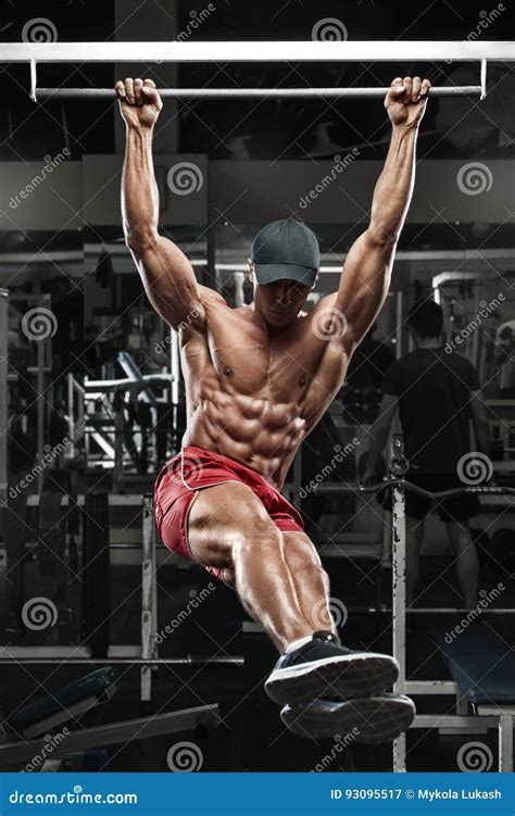 Muscular Man Working Out In Gym Doing Stomach Exercises On A