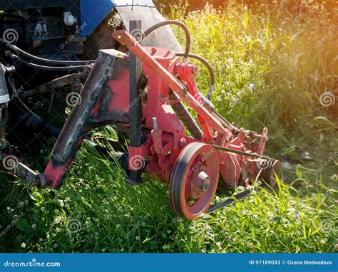 Farm Tractor Green Mowing High Grass In A Sunny Summer Day Close Up
