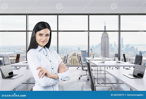 Smiling Brunette Business Lady With Cross Hands Is Standing In A Modern