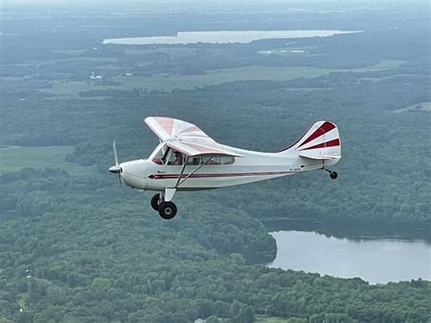 Aeronca Champ Flying Over Lush Green Forest