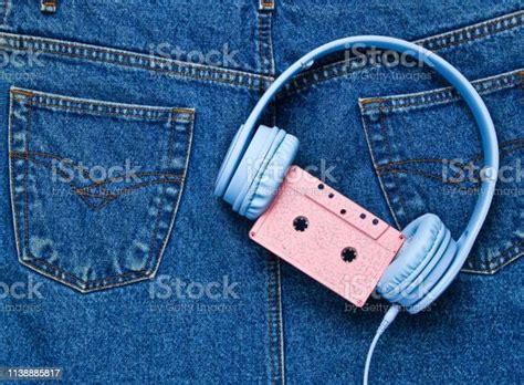 레트로 스타일 80 년대 헤드폰 청바지의 뒷 주머니에 오디오 카세트 팝 문화 Minimalism 평면도 0명에 대한 스톡 사진