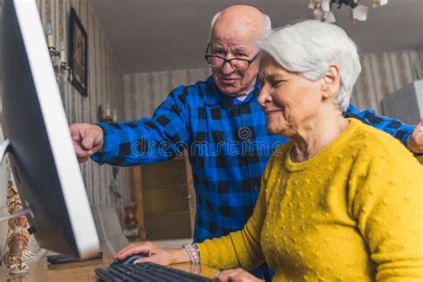 Senior Modern Experienced Man Pointing At The Monitor And Explaining