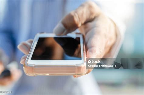 5g 기술 월드 와이드 웹 연결closeup 비즈니스 맨 을 사용하여 손으로 입력 스마트 폰과 일출 및 건물 배경과 도시에서 야외 응용 프로그램 장치와 터치 스크린 작업