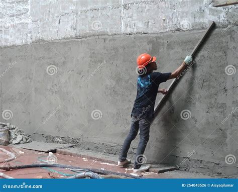 Construction Workers Plastering Building Wall Using Cement Plaster With