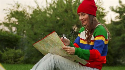 Young Woman In A Red Hat Checks The Map A Caucasian Woman Examines A