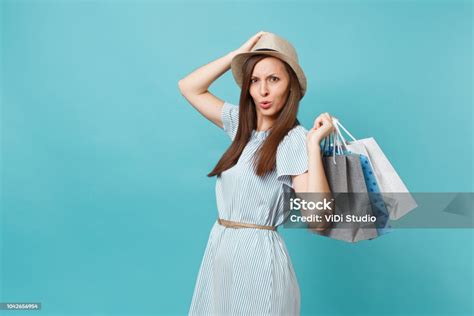 초상화 유행 웃는 아름 다운 백인 여자 여름에 드레스 밀 짚 모자 블루 파스텔 배경에 고립 쇼핑 후 구매와 패키지 가방을 들고