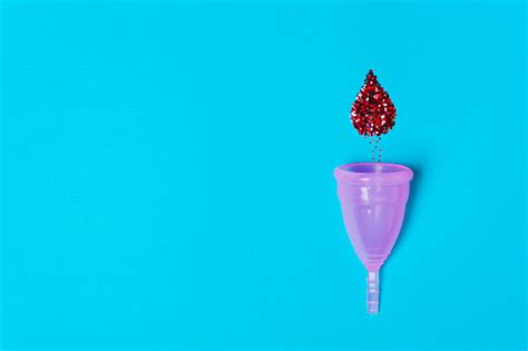분홍색 생리컵과 파란 배경에 피 한 방울이 있습니다 여성의 건강 위생적인 보호 수단 생리 0명에 대한 스톡 사진 및 기타 이미지