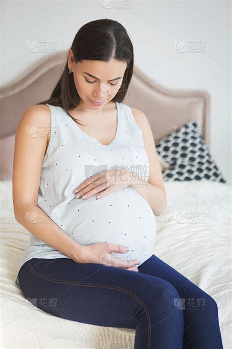 孕妇坐在室内的床上