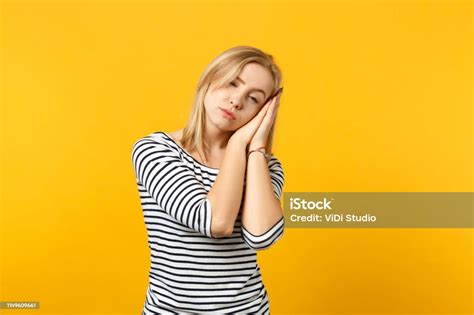 깜박임 노란색 오렌지 벽 배경에 고립 된 뺨에서 접힌 손으로 수 면 카메라를 찾고 줄무늬 옷에 젊은 여자 사람들은 진심으로 감정 라이프 스타일 개념입니다 복사 공간을 모의