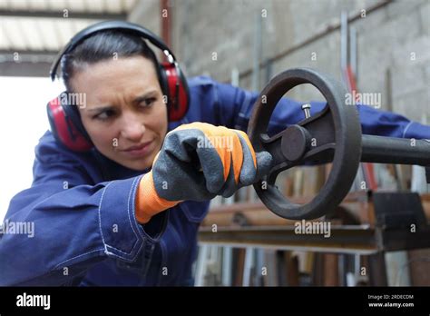 Portrait Of Ordinary Efficient Female Engineer Rotating Valve Inside