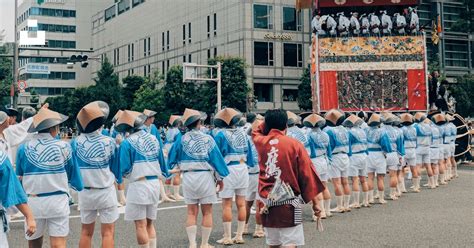 파란 제복을 입은 한 무리의 사람들이 거리를 행진하고 있다 사진 Unsplash의 무료 교토 이미지