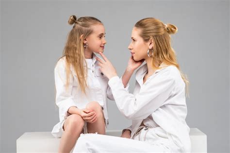 Premium Photo Long Haired Good Looking Sisters In White Outfits Gently Touching Each Other