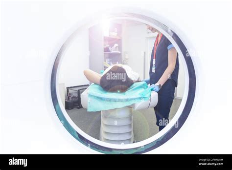 Ct Scan Technologist Overlooking Patient In Computed Tomography Scanner