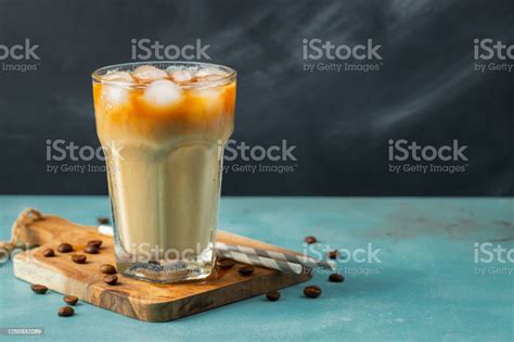 크림을 뿌린 높은 유리에 아이스 커피를 쏟아붓고 가벼운 돌 배경에 커피 콩을 뿌립니다 튜브가있는 추운 여름 음료 복사 공간 0명에 대한 스톡 사진 및 기타 이미지 Istock