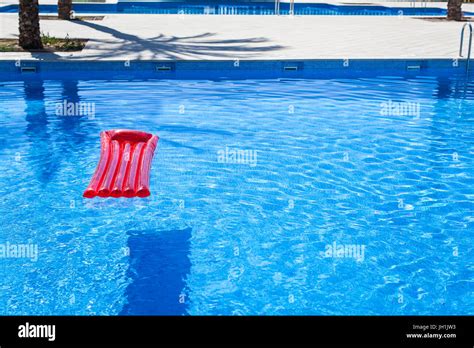 Red Inflatable Lilo Lounger Floating In A Swimming Pool Stock Photo Alamy
